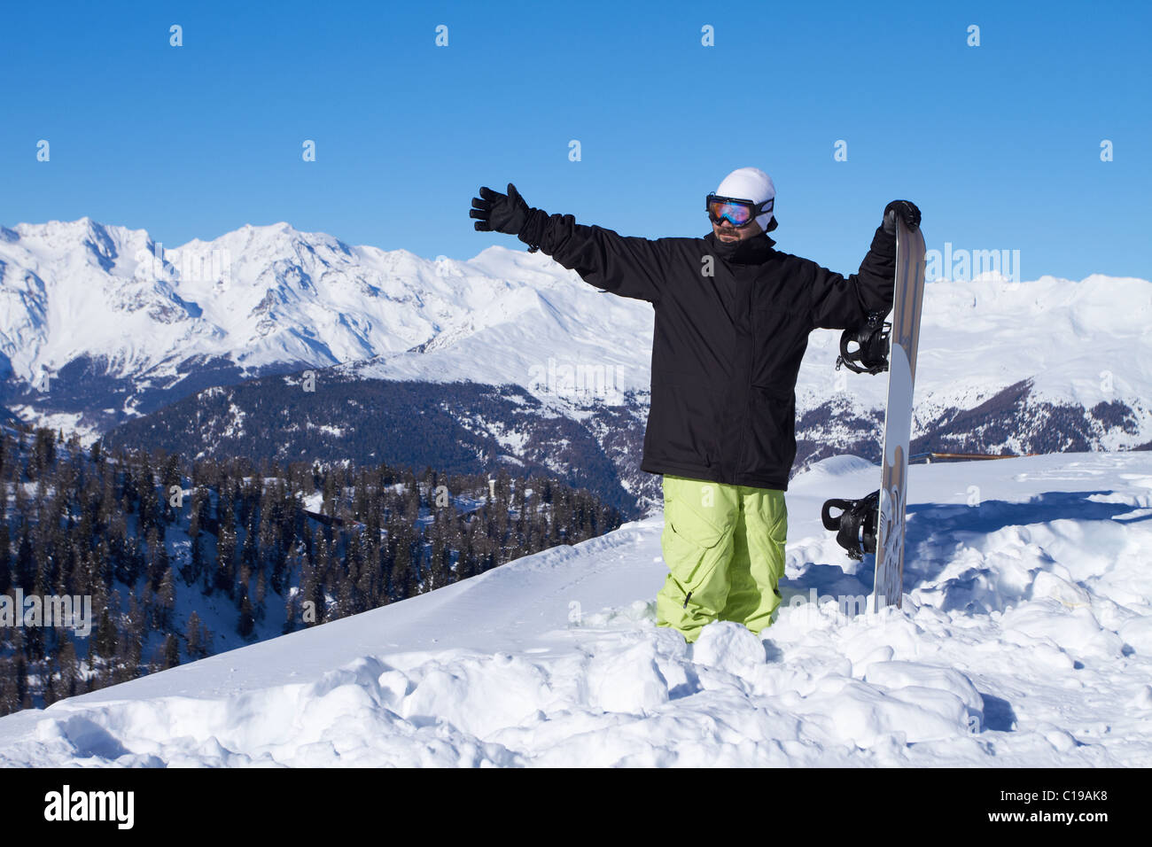 Sporty male snowboarder pointing hand in his right Stock Photo - Alamy