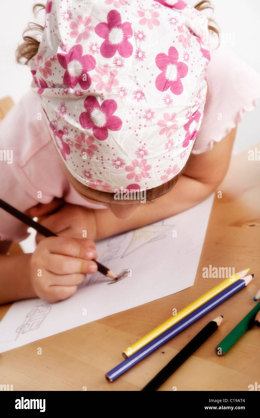 Girl, 6, drawing while sitting at a desk Stock Photo - Alamy