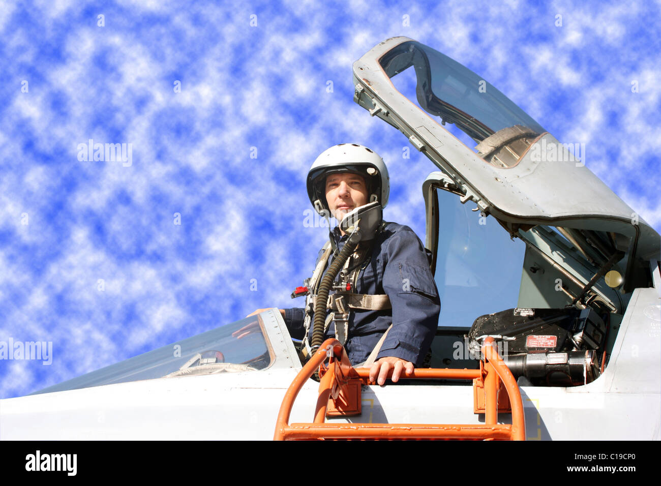 The military pilot in the plane in a helmet in dark blue overalls ...