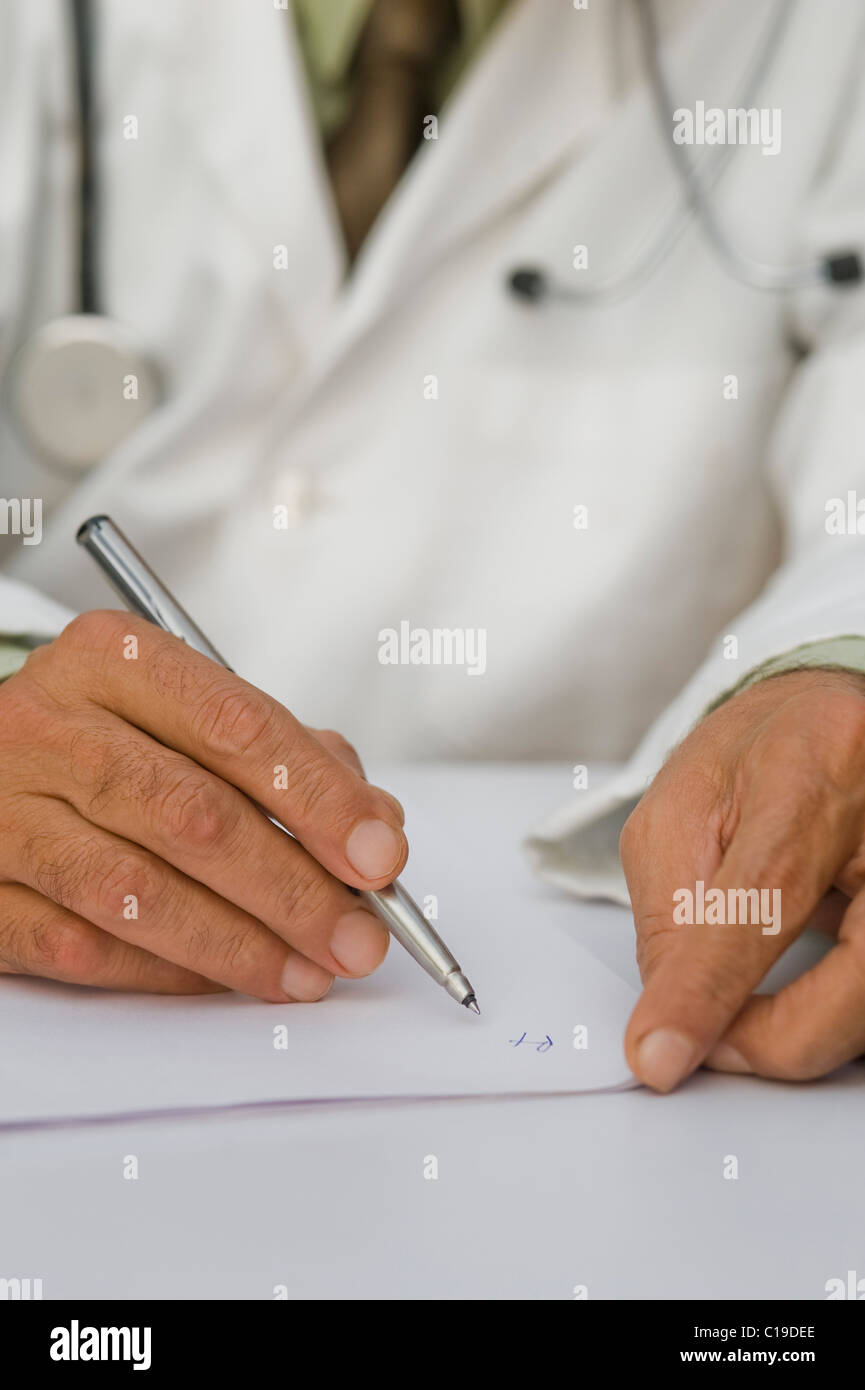 Doctor writing on a sheet of paper Stock Photo - Alamy