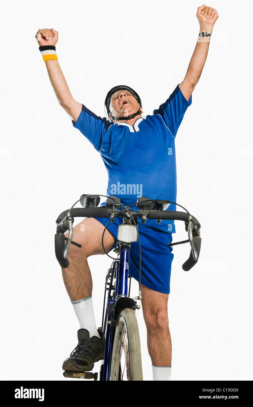 Man cheering on a bicycle with his arms raised Stock Photo - Alamy