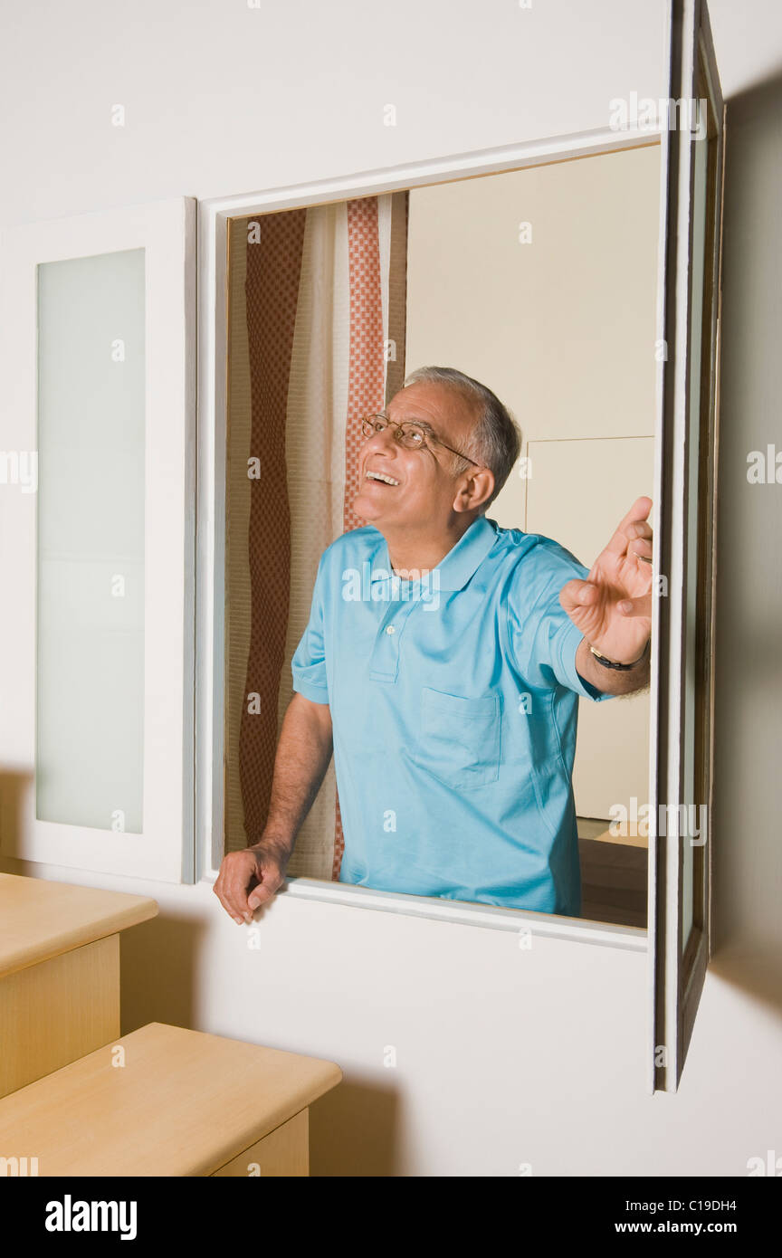 Man looking through a window Stock Photo - Alamy