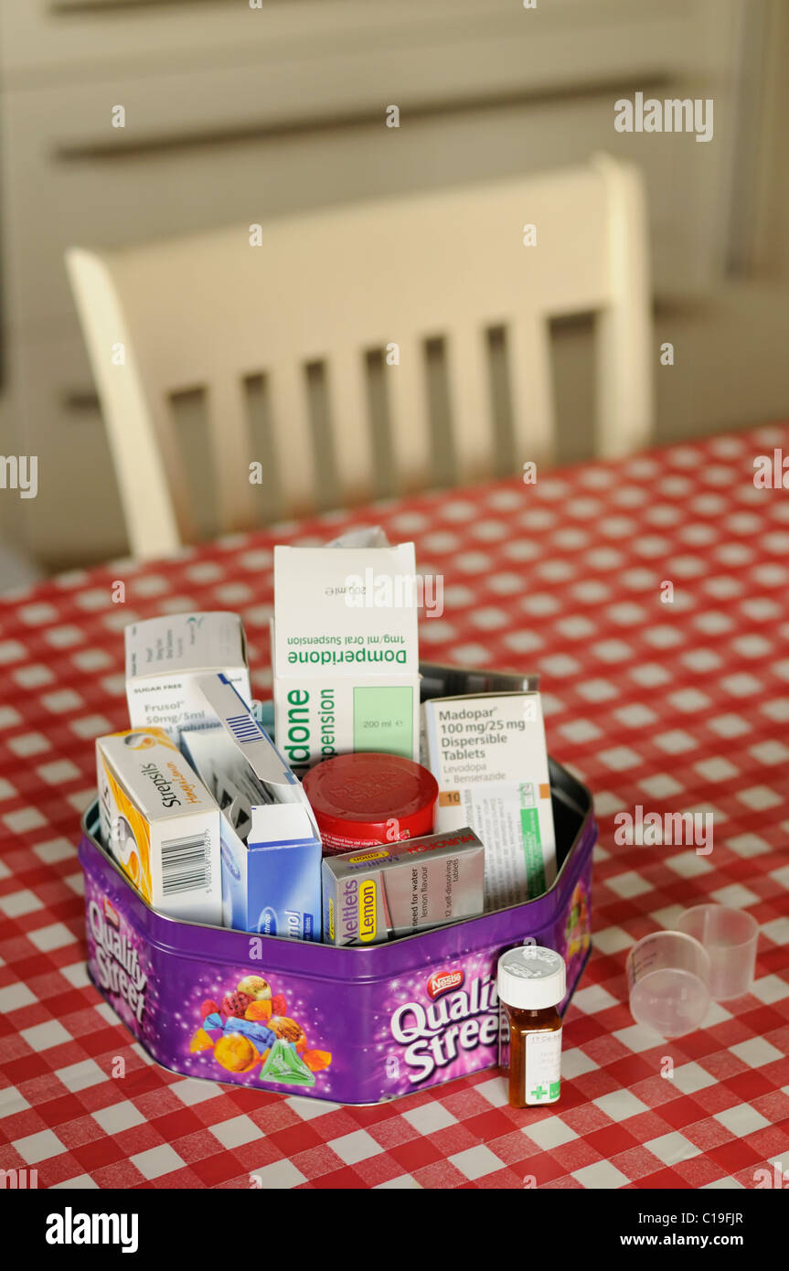 An elderly person's medication in a tin on a kitchen table Stock Photo ...