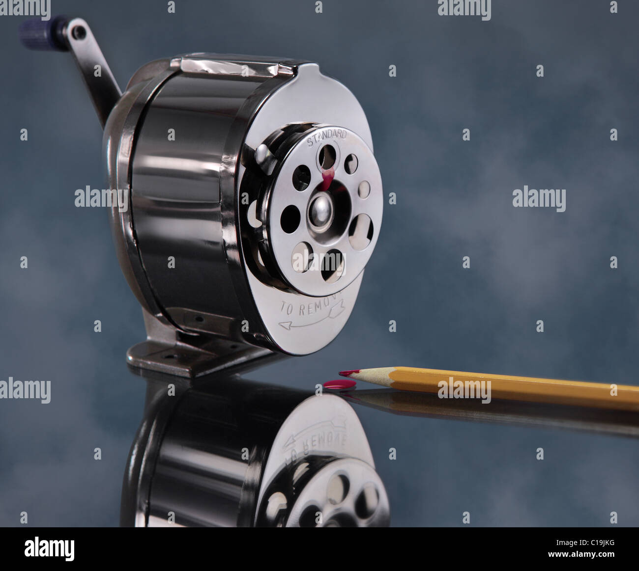 rotary pencil sharpener and bloodied tip of pencil on mirror tinted ...