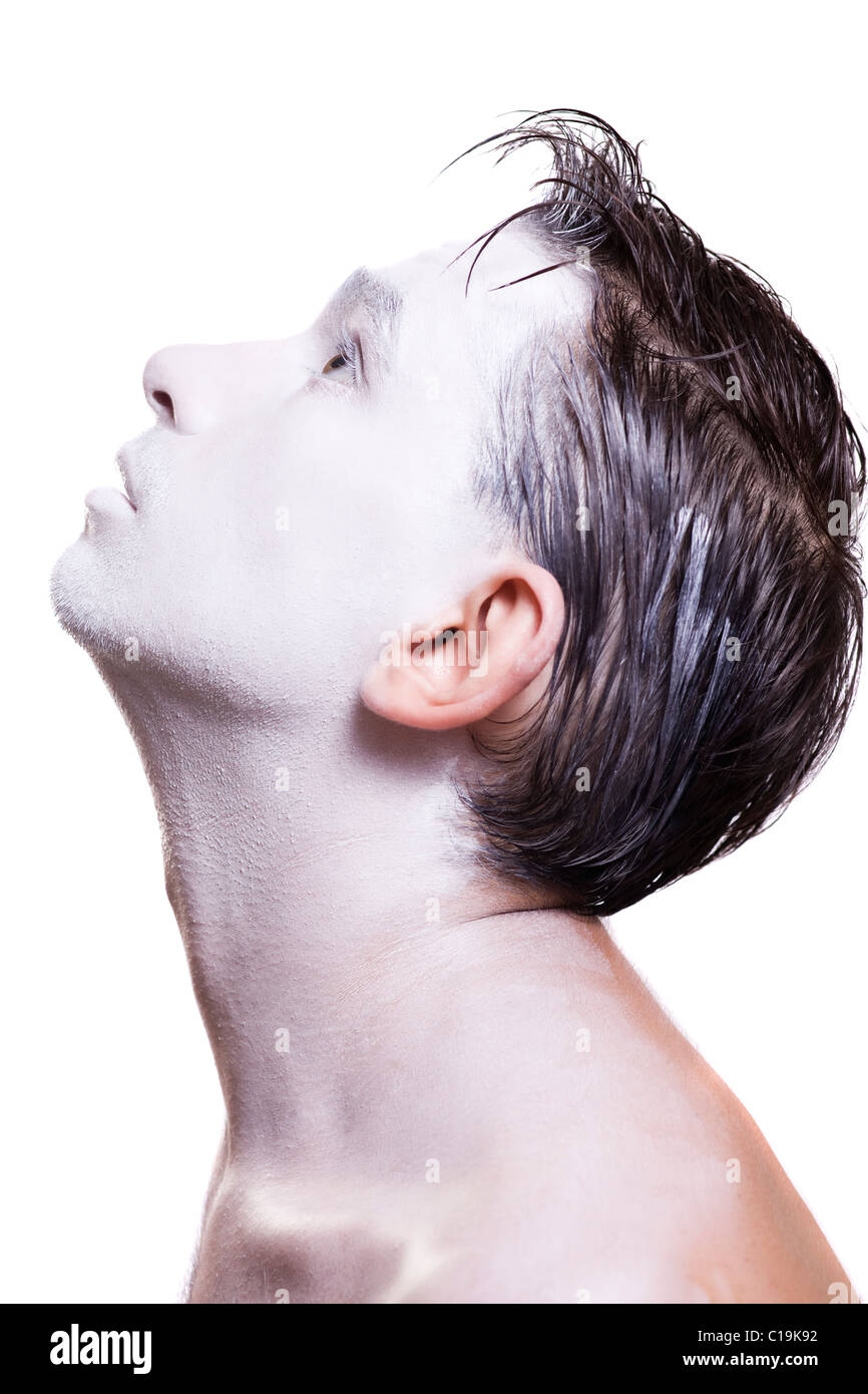 Profile of beautiful young guy with white makeup isolated on white ...