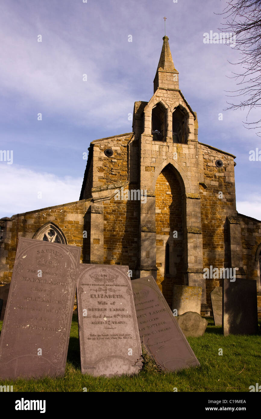 Leaning headstones in front of the tower of St. James Church, Burton ...