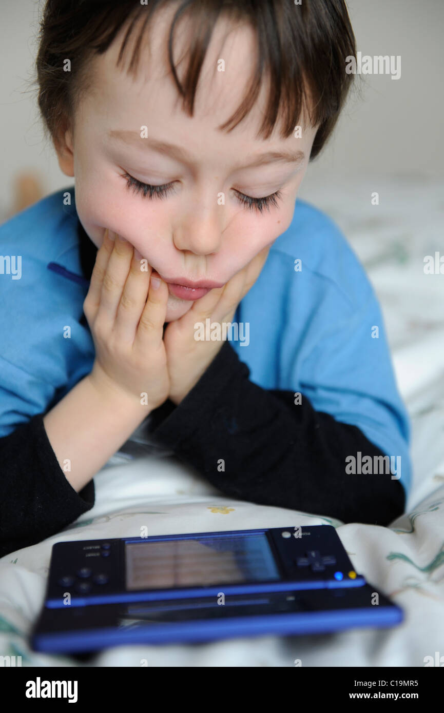 6 year old playing on a nintendo DSi handheld game console Stock Photo ...