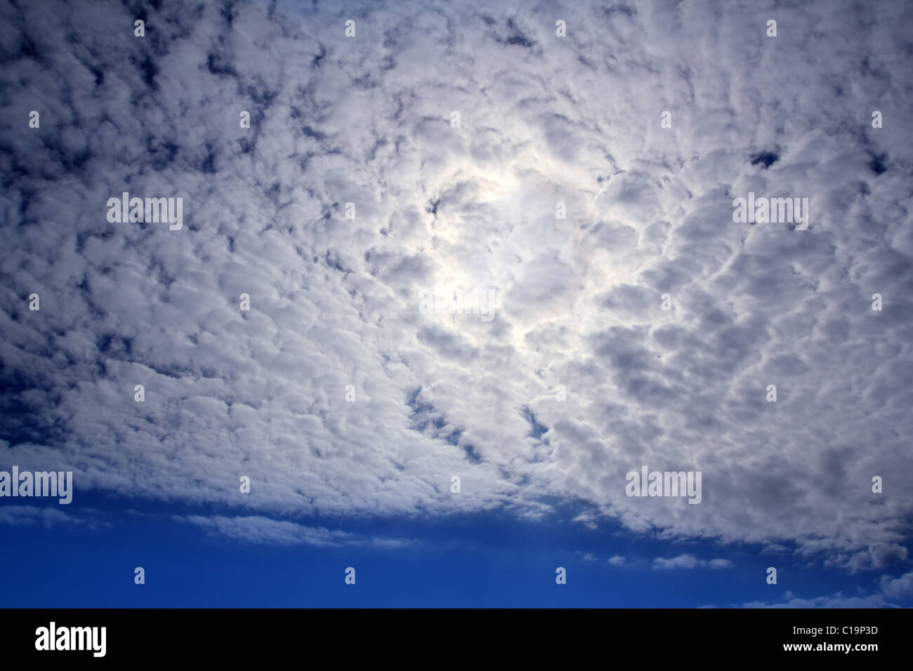 cirrocumulus clouds with sun glowing transparent in blue sky Stock ...