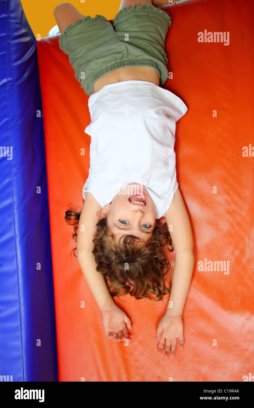 upside down little girl on playground slide laughing happy play Stock ...