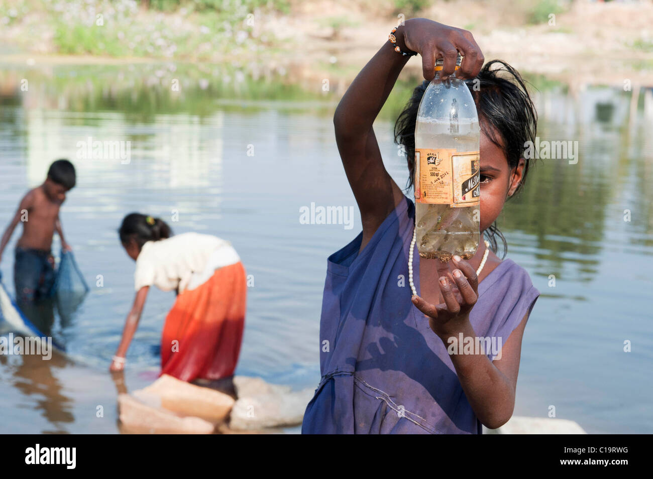 Poor indian lower caste children fishing in the river with a sari and ...