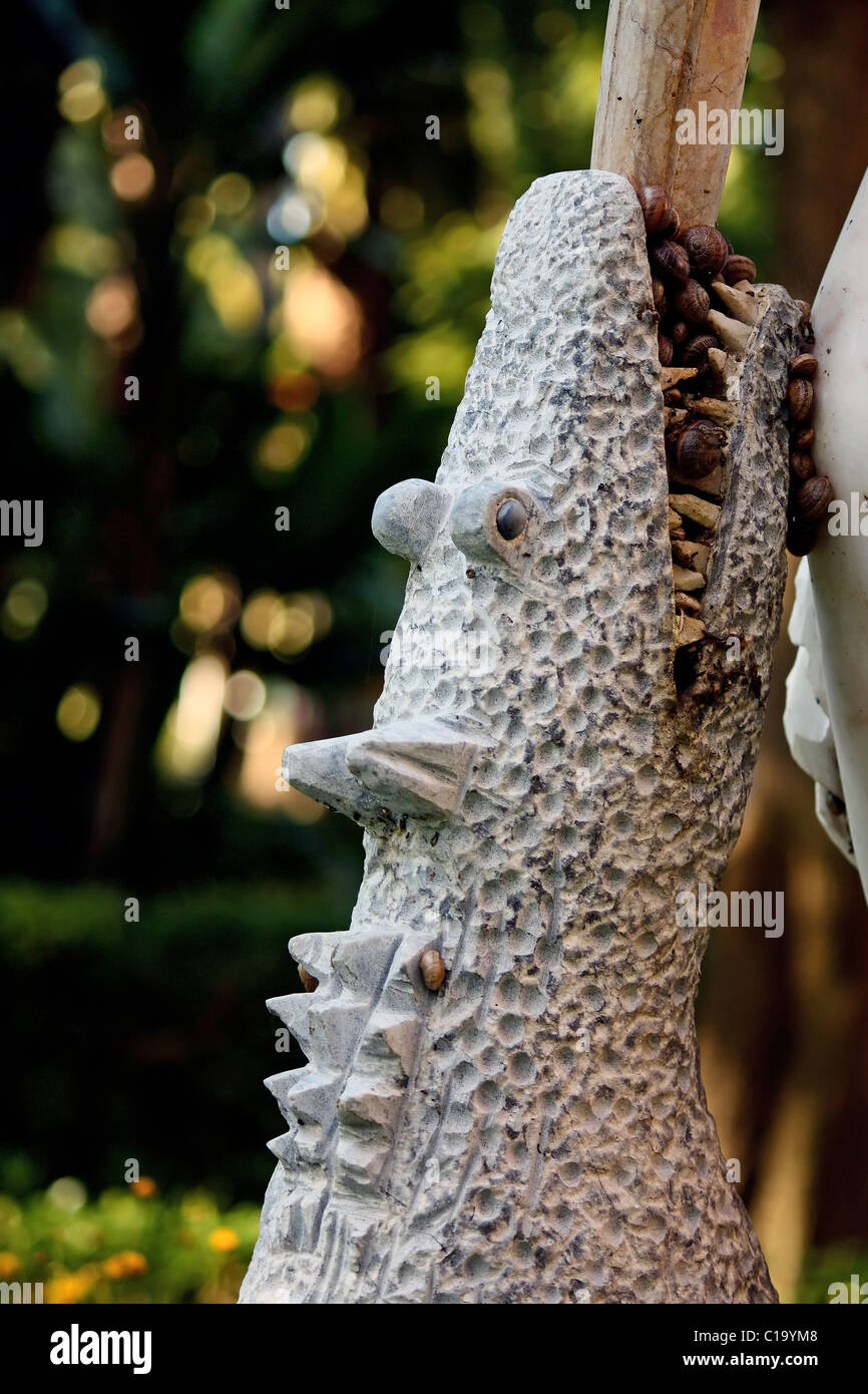 Crazy statue of a stork feeding a croc, with snails on his mouth on a ...