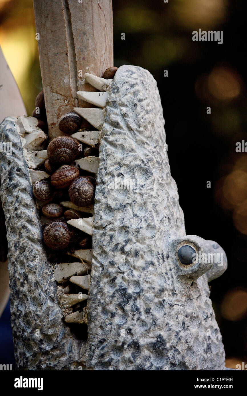 Crazy statue of a stork feeding a croc, with snails on his mouth on a ...
