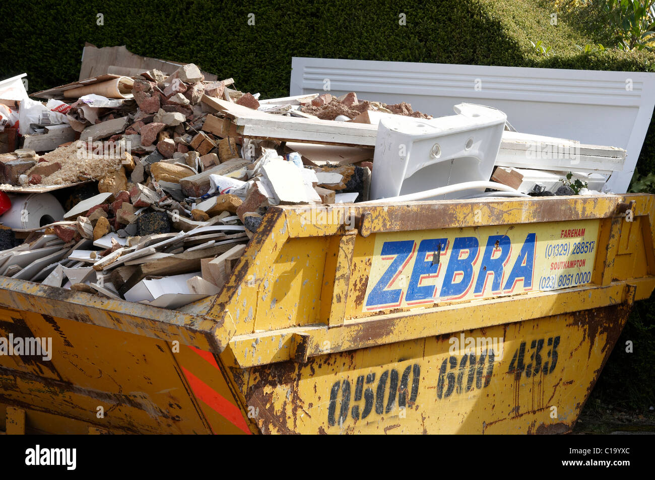 Builder's skip with rubble and other waste Stock Photo - Alamy