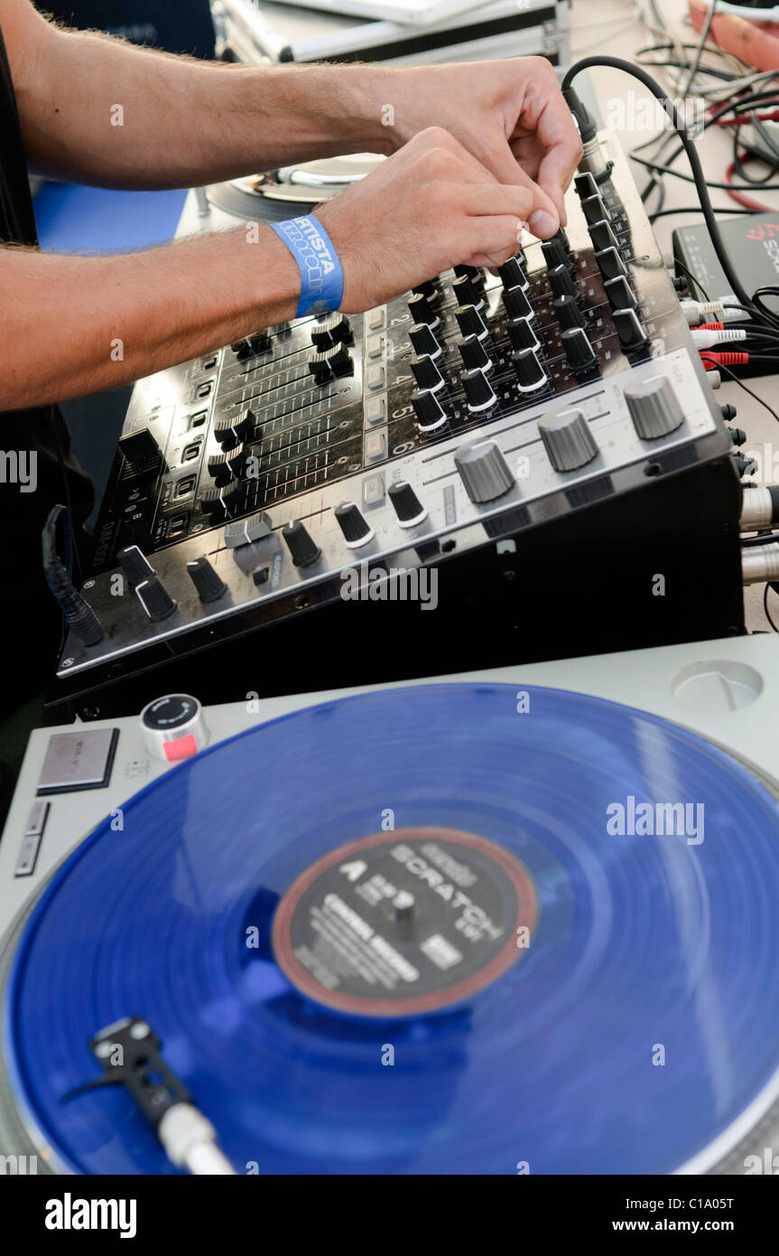 DJ mixing using mixer and blue scratch Vinyl record Stock Photo - Alamy