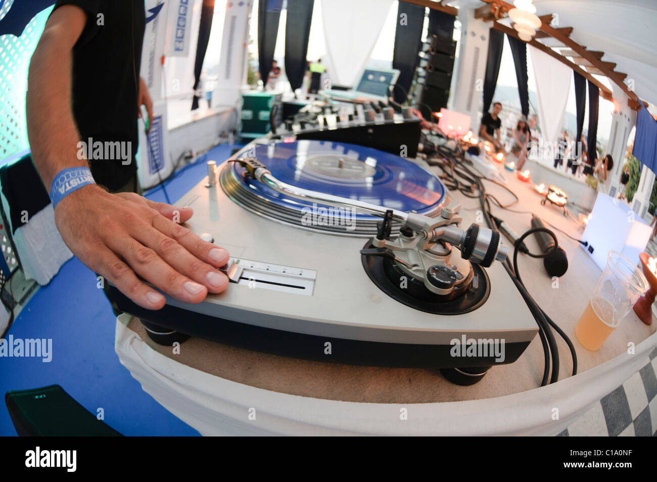 DJ performing live, mixing music using mixer and scratch vinyl record ...