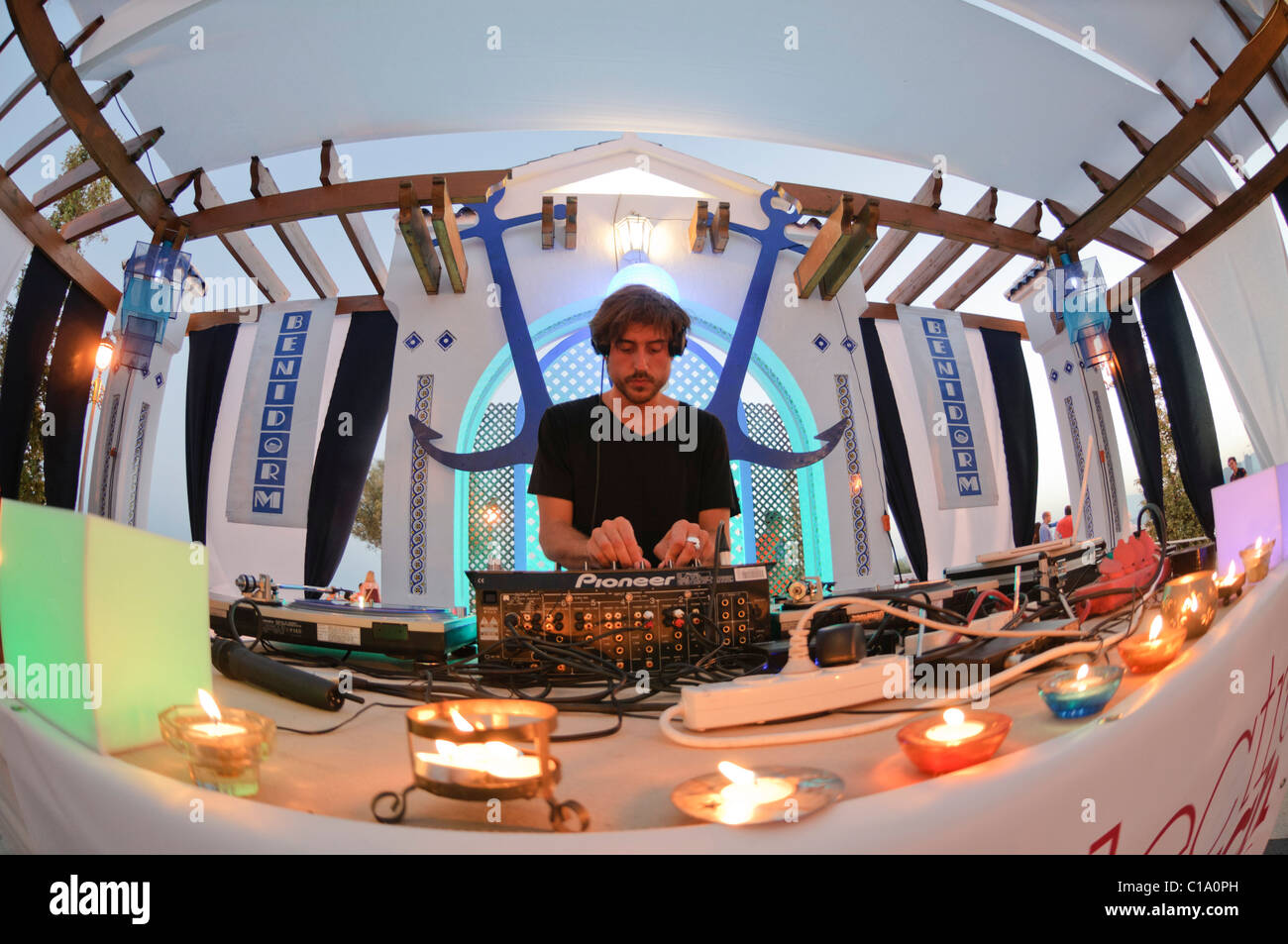 DJ performing live, mixing music using mixer and scratch vinyl record ...