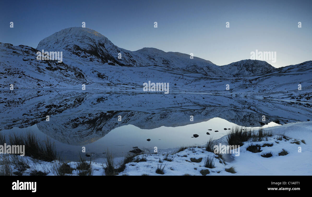 Great End and Scafell Pike reflected in Styhead Tarn in winter in the ...