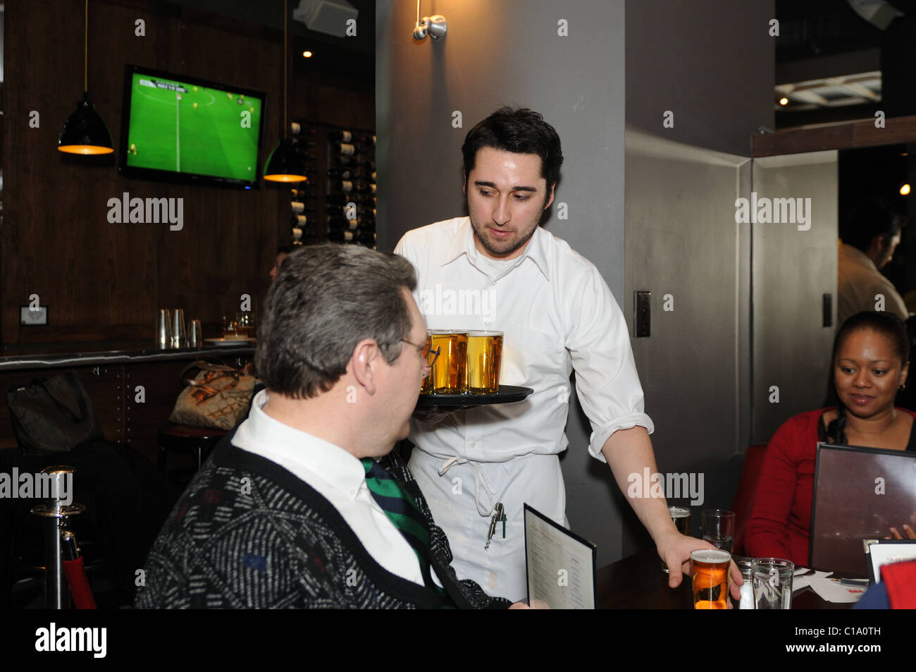 A waiter at The Bailey, an Irish restaurant in Lower Manhattan, serving ...
