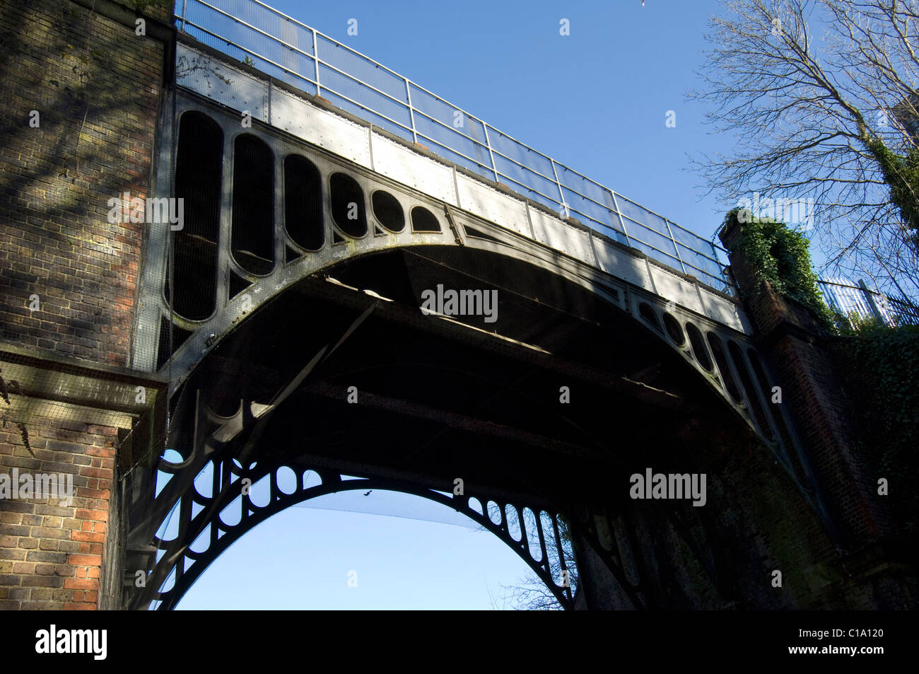 A Victorian brick and ironwork railway bridge spanning a road in ...