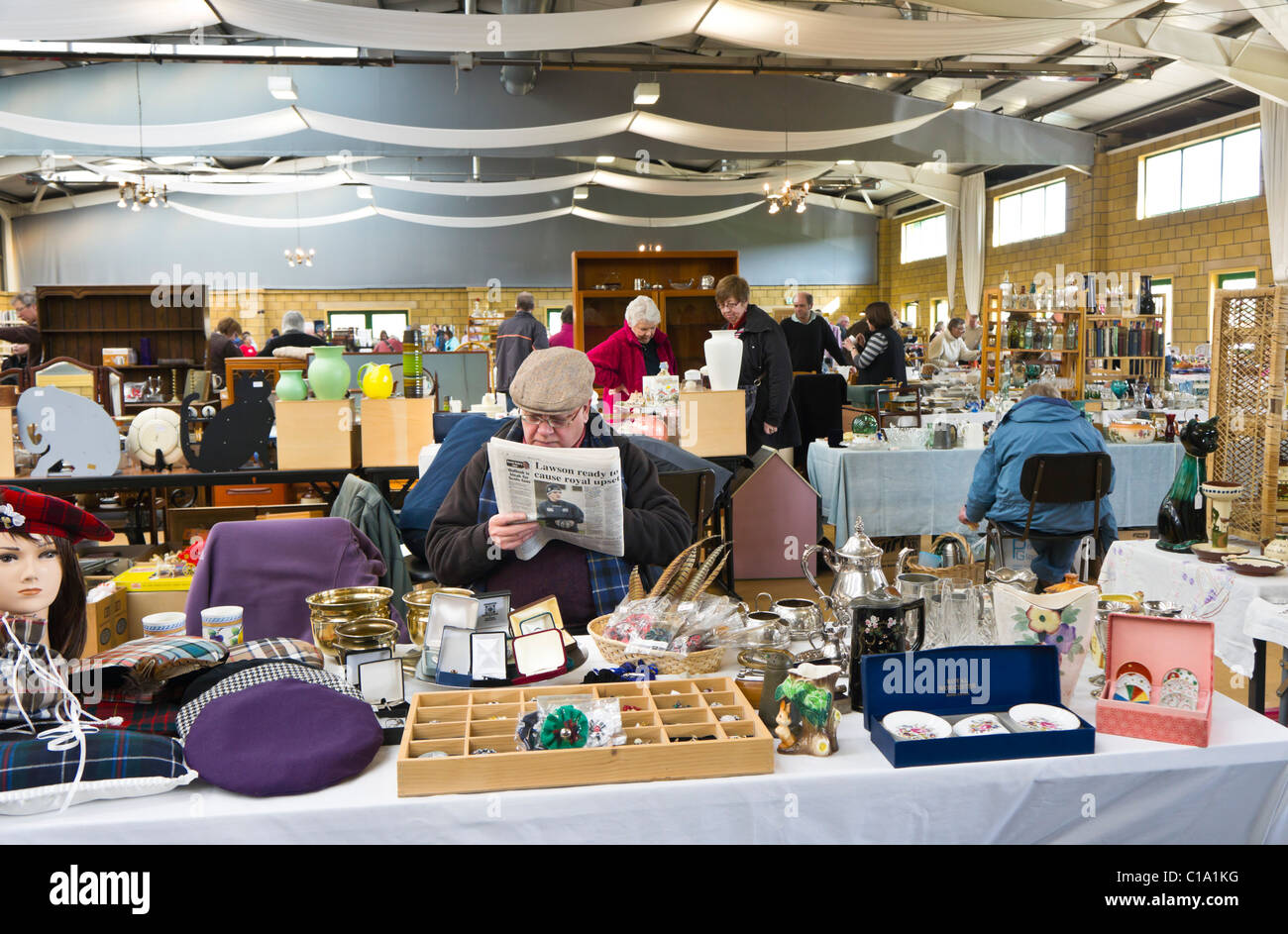 The old-fashioned way of reading - antiques fair stallholder reading a ...
