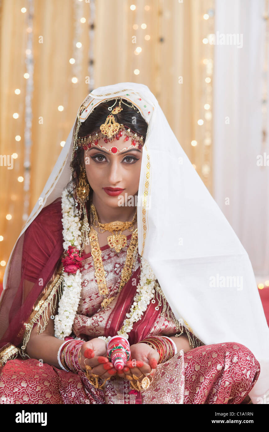Portrait of a bride holding sindoor in Bengali wedding Stock Photo - Alamy