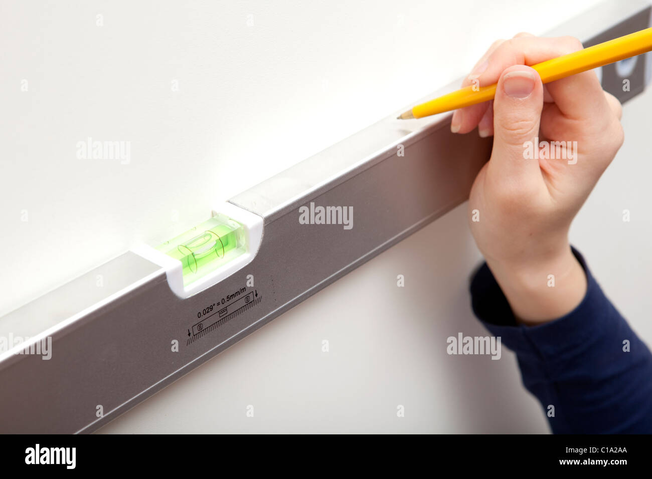 A woman using a spirit level to complete a DIY task Stock Photo - Alamy