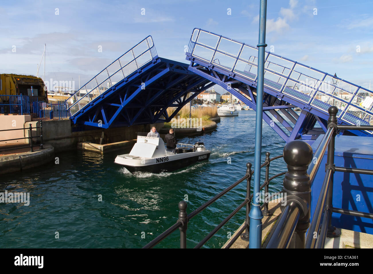 Small boat passing under raised bridge, Sovereign harbour, Eastbourne ...