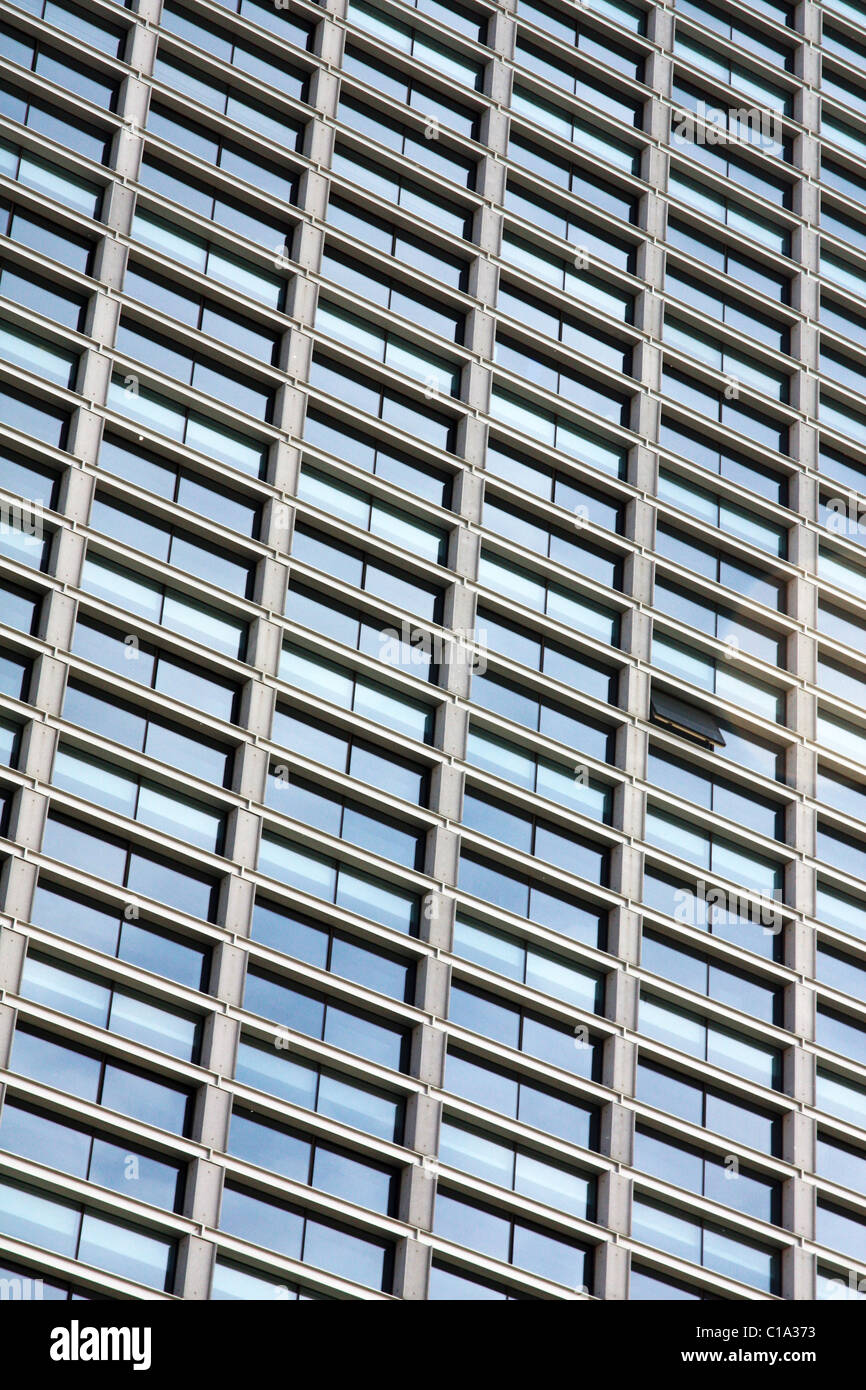 View of a tall modern building with many windows but only one is opened ...