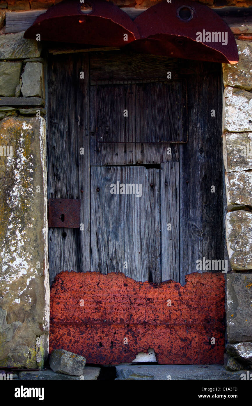 Detail of an old rusty door on a stone house Stock Photo - Alamy