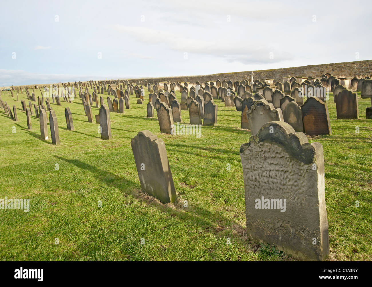 Large traditional church cemetery in the countryside with headstones ...