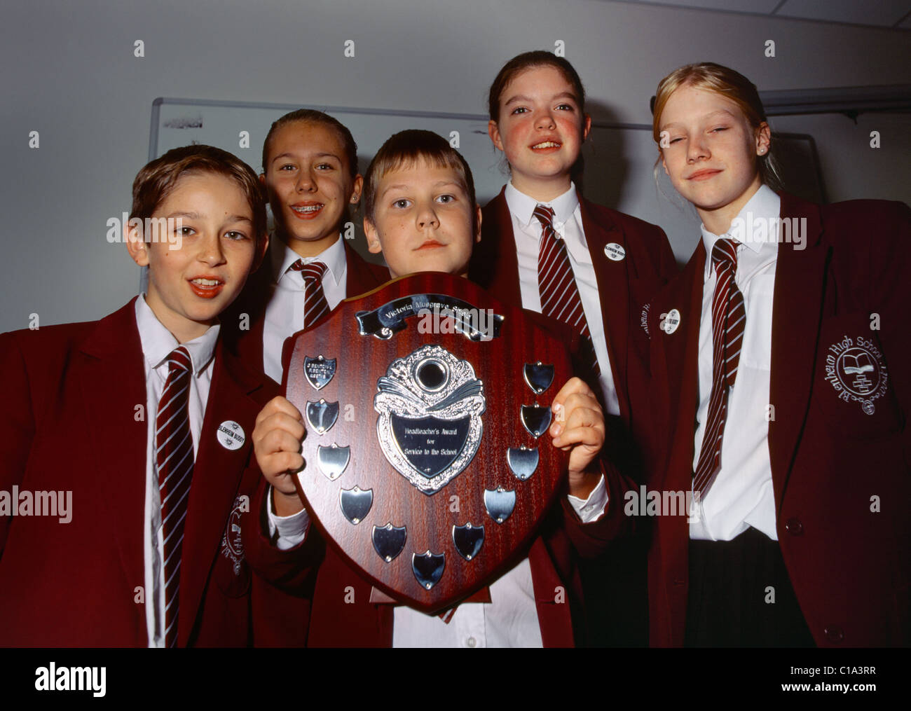 High School Team Of Children With Shield Holding Up Shield Stock Photo ...