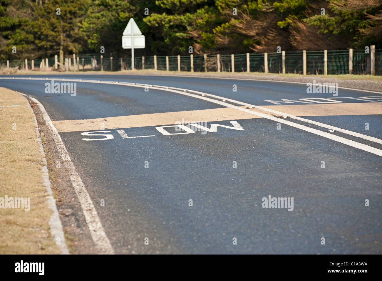 Slow warning sign at the approach to a bend on country road Stock Photo ...