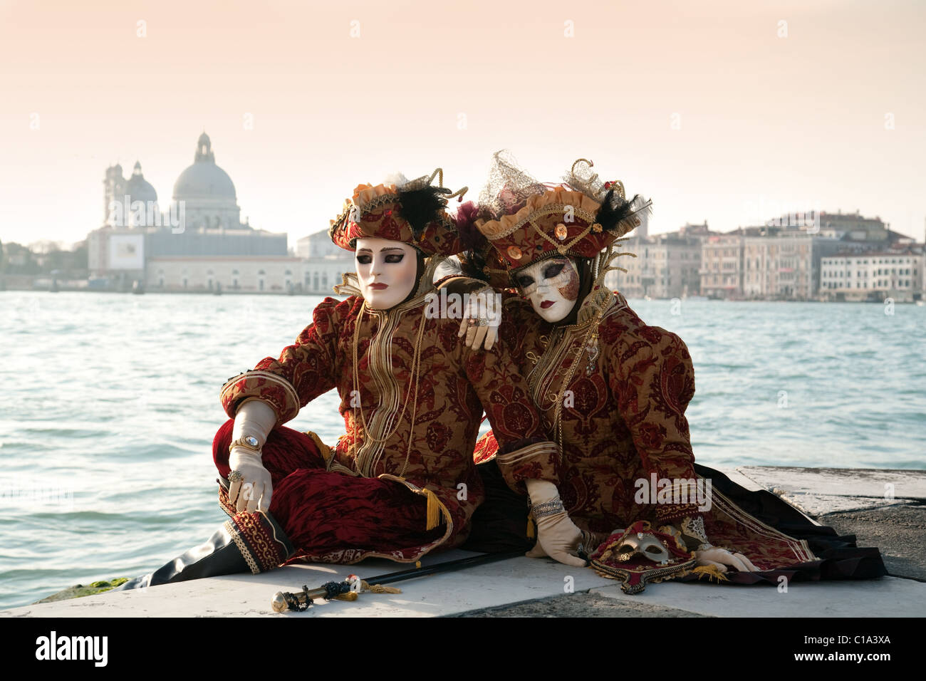 Two models (masqueraders) posing by the Grand Canal at sunset, the ...