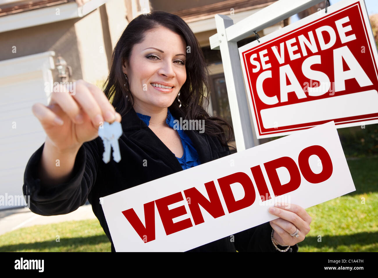 Happy Attractive Hispanic Woman Holding Vendido Real Estate Sign and ...