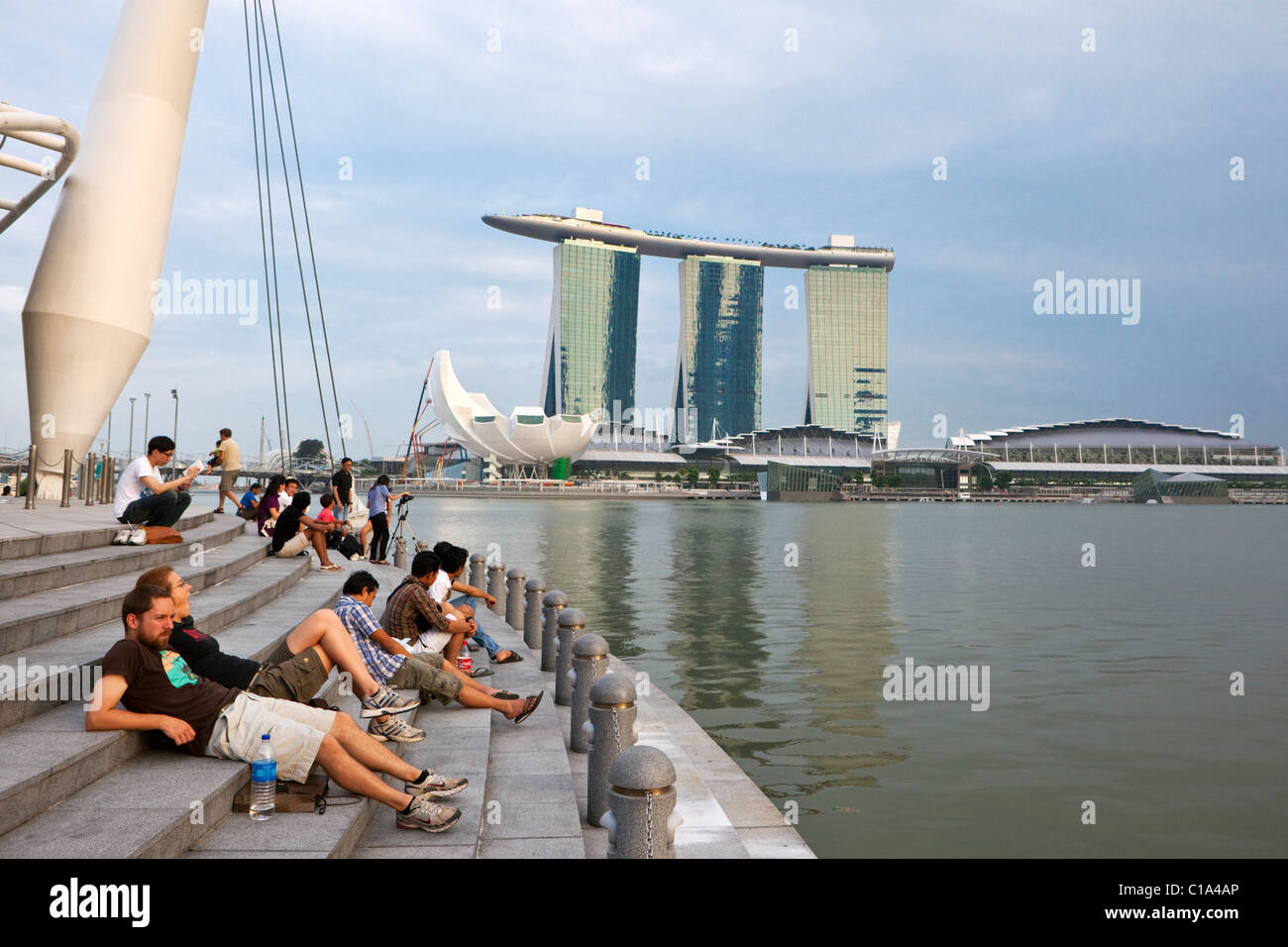 Tourists relaxing on the waterfront with the Marina Bay Sands Singapore ...