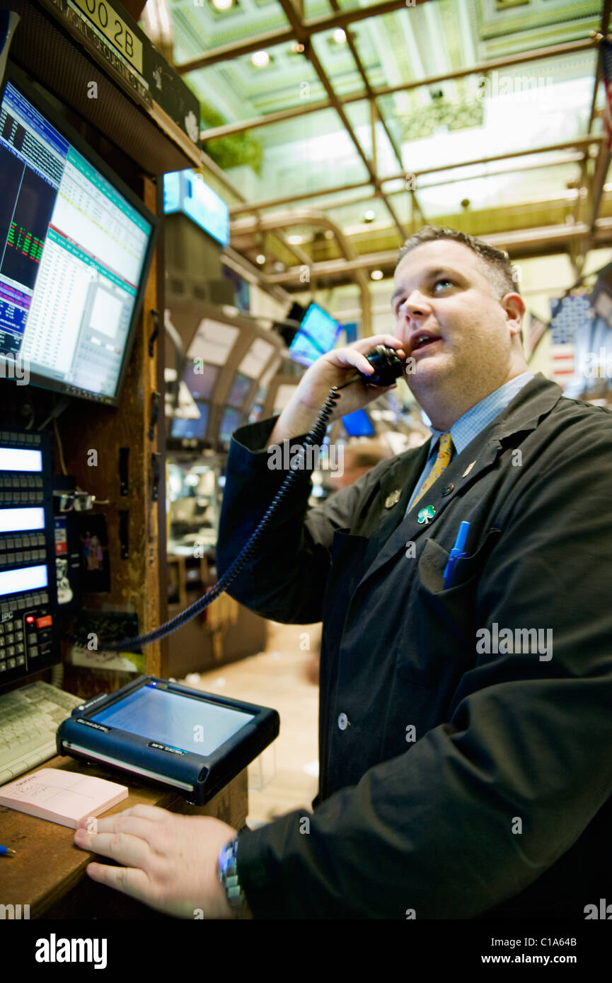 A securities trader using a phone on the floor of the New York Stock ...