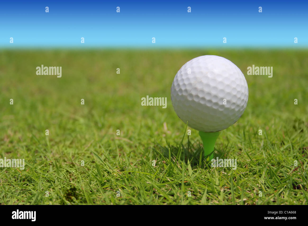 Golf ball on the pin in Grass Stock Photo - Alamy