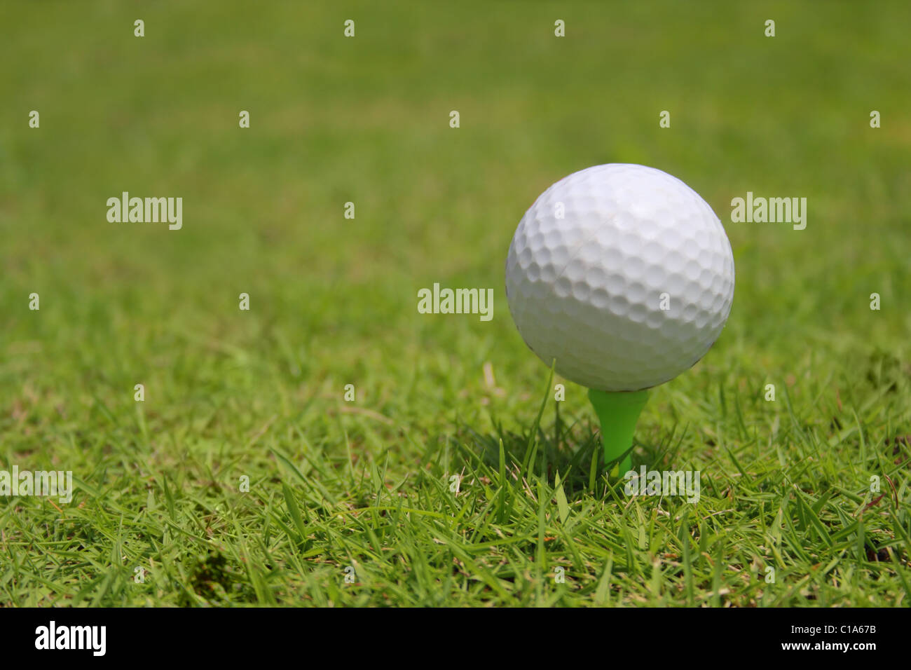 Golf ball on the pin in Grass Stock Photo - Alamy