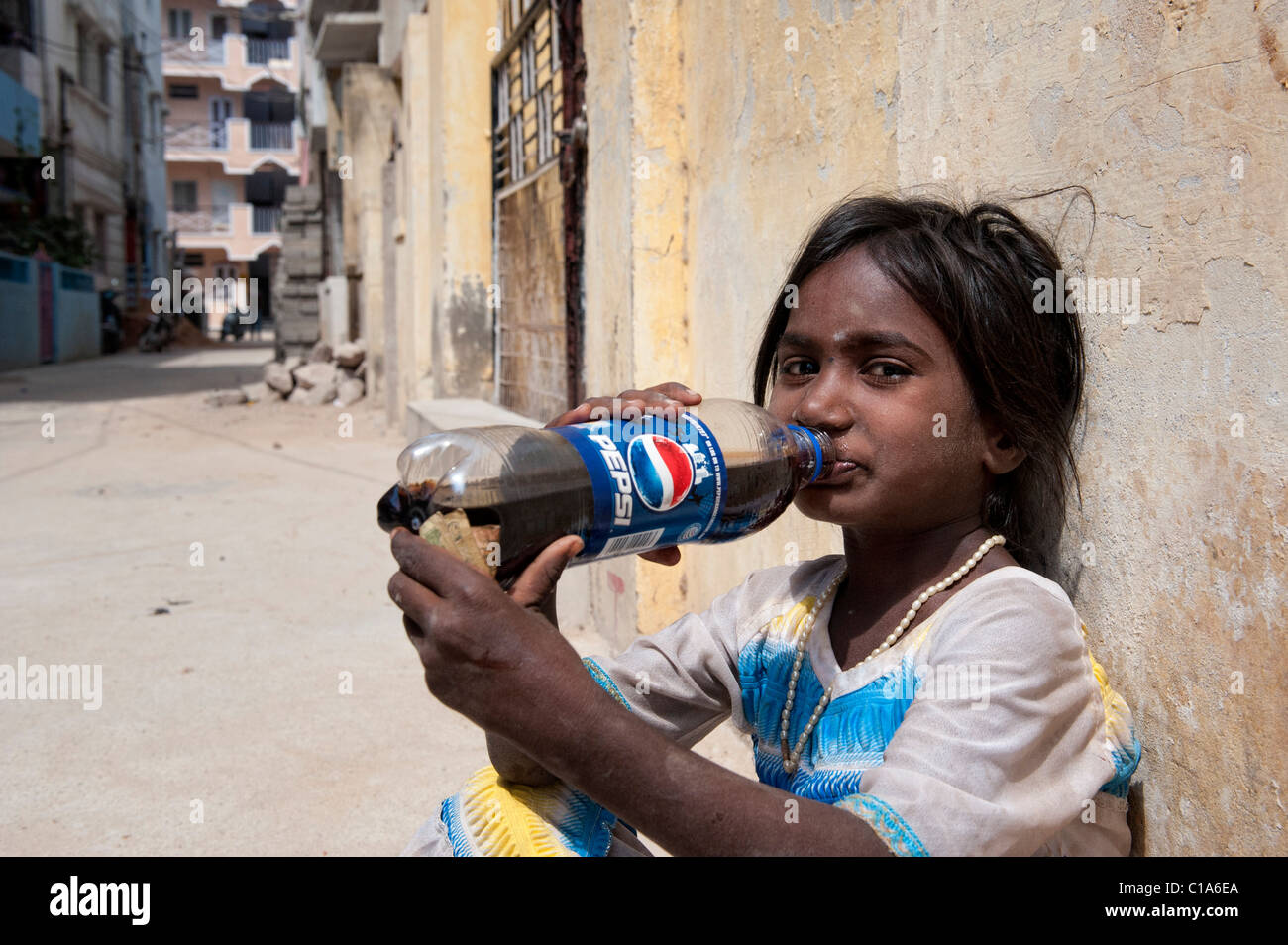 Happy young poor lower caste Indian street girl drinking Pepsi. Andhra ...