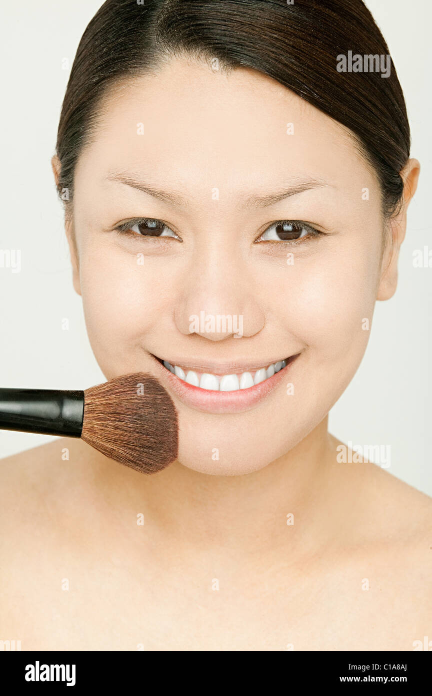 Young woman applying face powder Stock Photo - Alamy