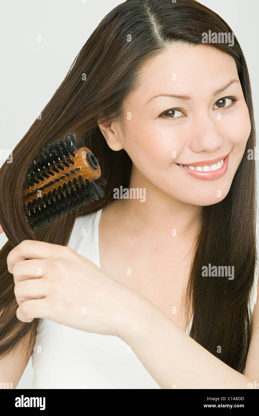Young woman brushing hair Stock Photo - Alamy
