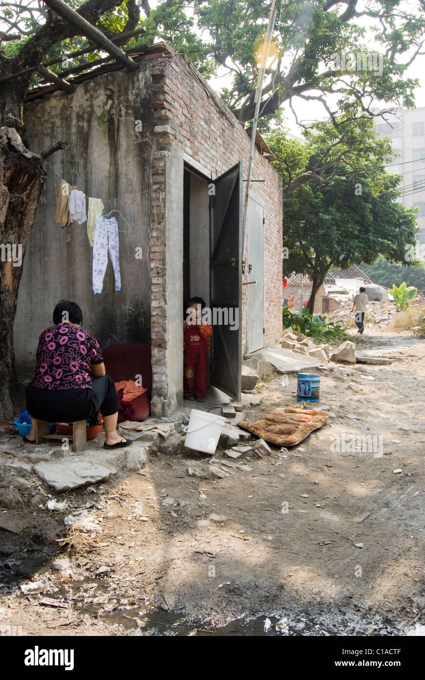 Grandmother and a toddler/ grandson outside their house. Very poor ...