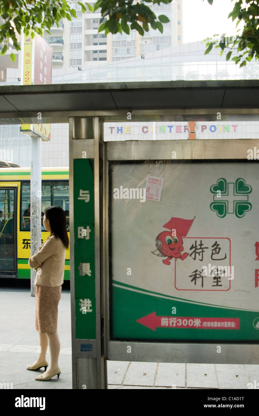 Chinese woman waiting for a bus on a bus stop in Dongguan Stock Photo ...