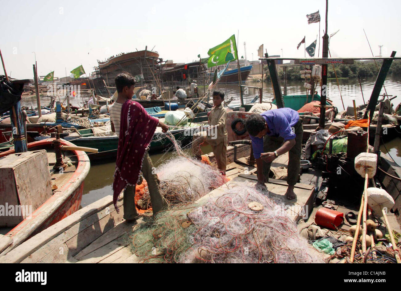 Two children busy to arrange fishnet to earn their livelihood for ...