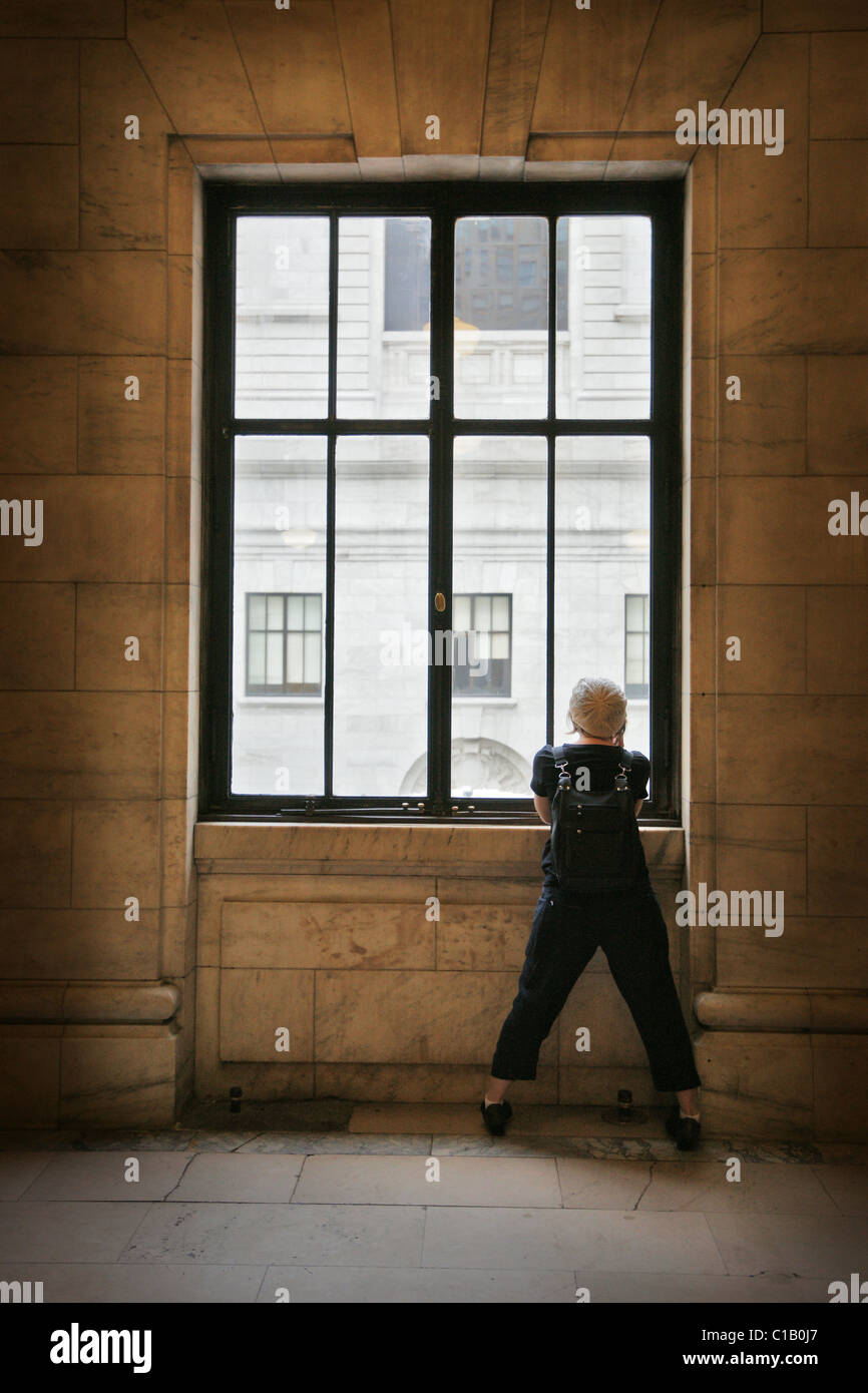 girl with hat looking out of a big window Stock Photo - Alamy