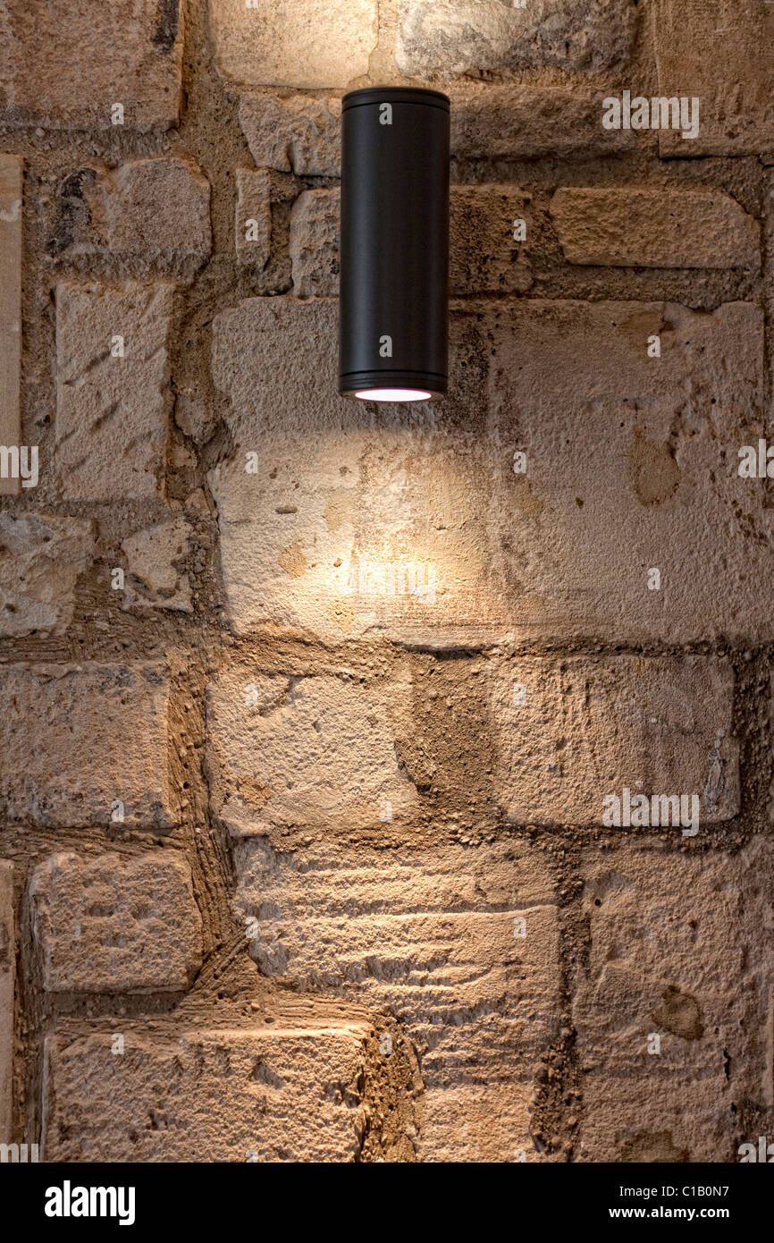 Downlighter shining on a stone wall Stock Photo - Alamy