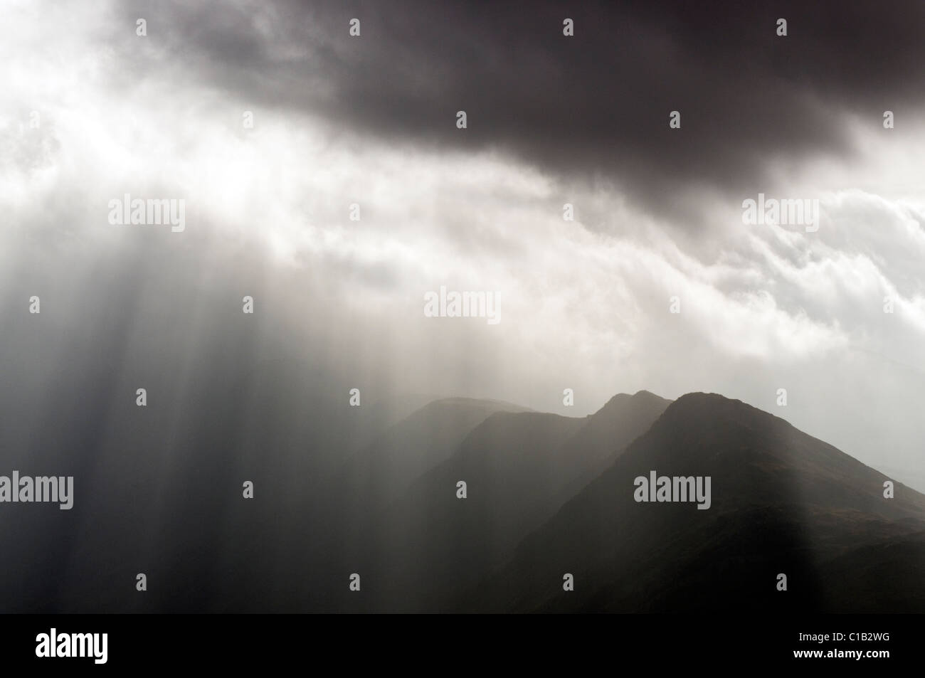 The main Llechog ridge on Snowdon, shrouded in cloud and rays of ...