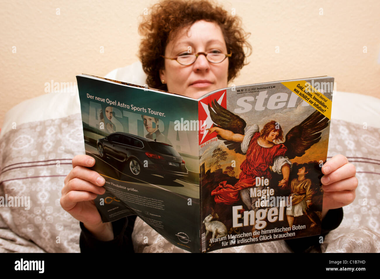 Woman in bed reading Stern magazine Stock Photo - Alamy