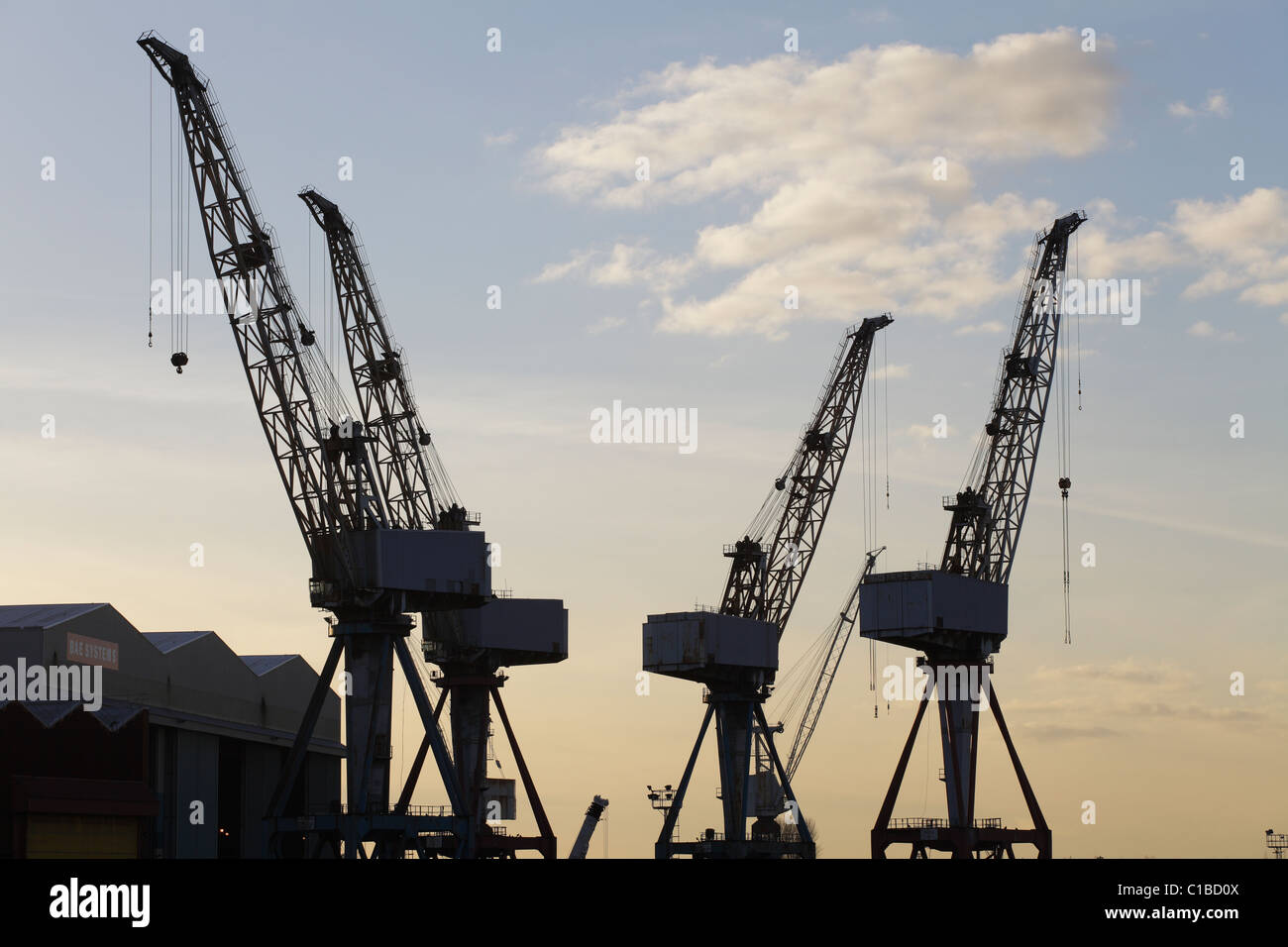 Shipyard cranes in BAE Systems beside the River Clyde at dusk in Govan ...