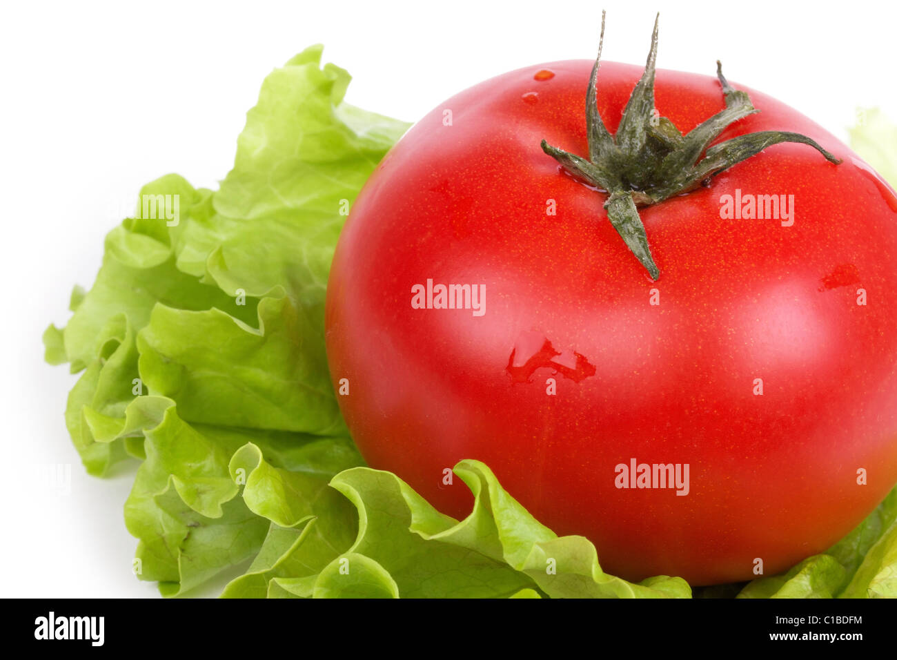 One tomato on salad leaf, closeup on white Stock Photo - Alamy